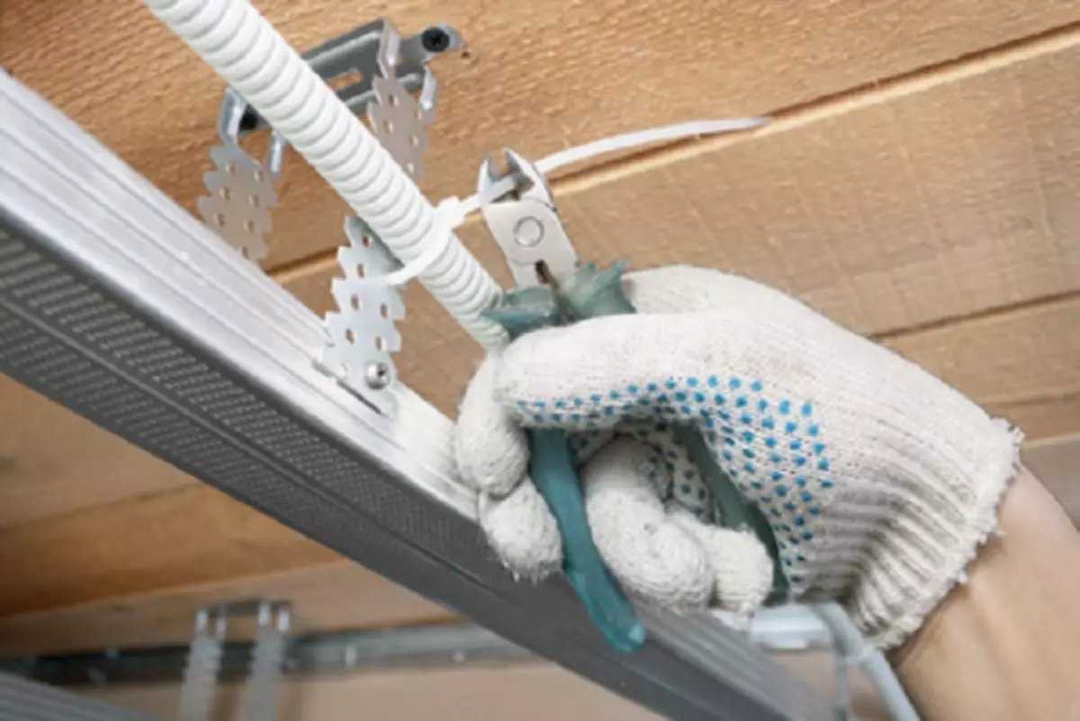 Kabel di bawah plafon ketegangan: perbaikan, penggantian, instalasi di bawah lampu